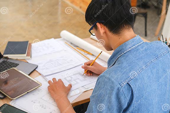 Architect and Engineer Drafting Blueprints with a Pencil and Ruler at a ...