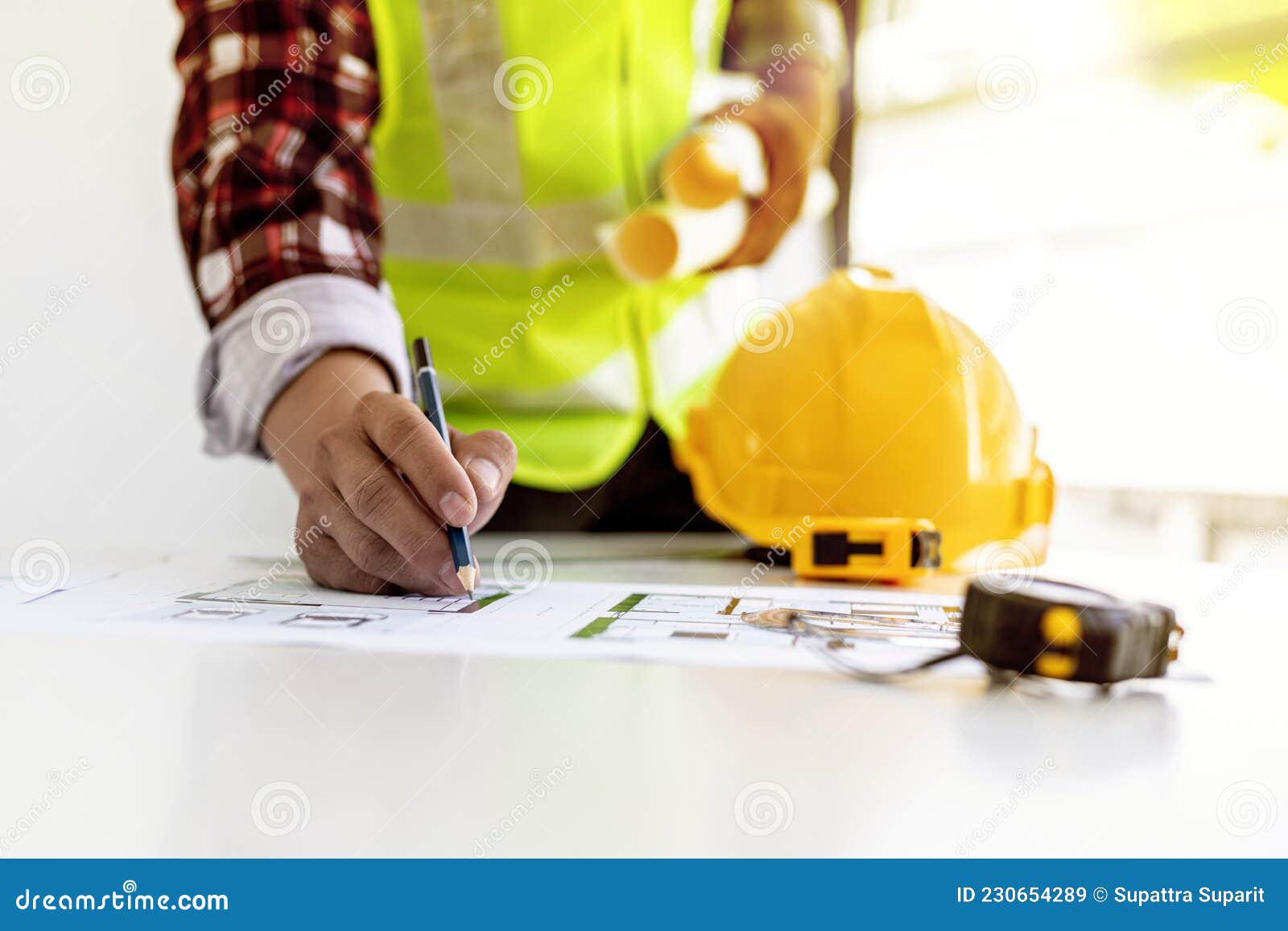 Architect Engineer Using a Pencil To Write on the Blueprints he Has ...