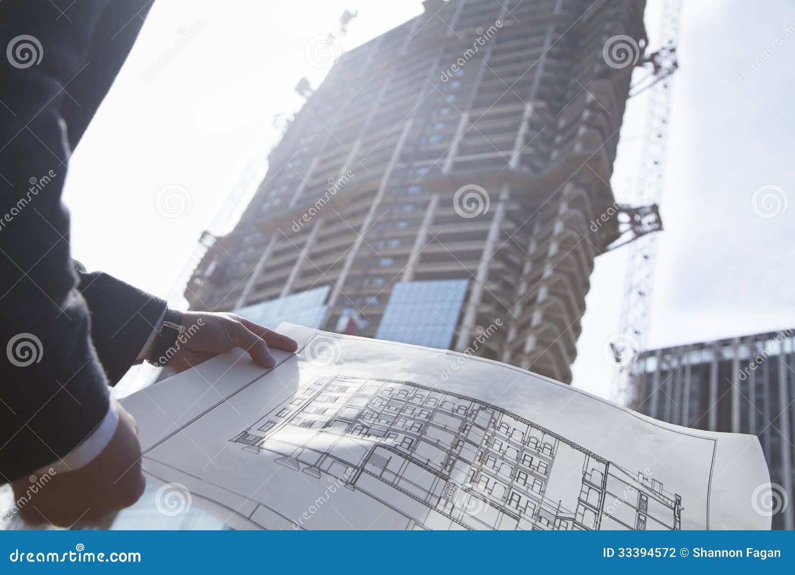 Architect Holding Blueprint of Building at a Construction Site ...