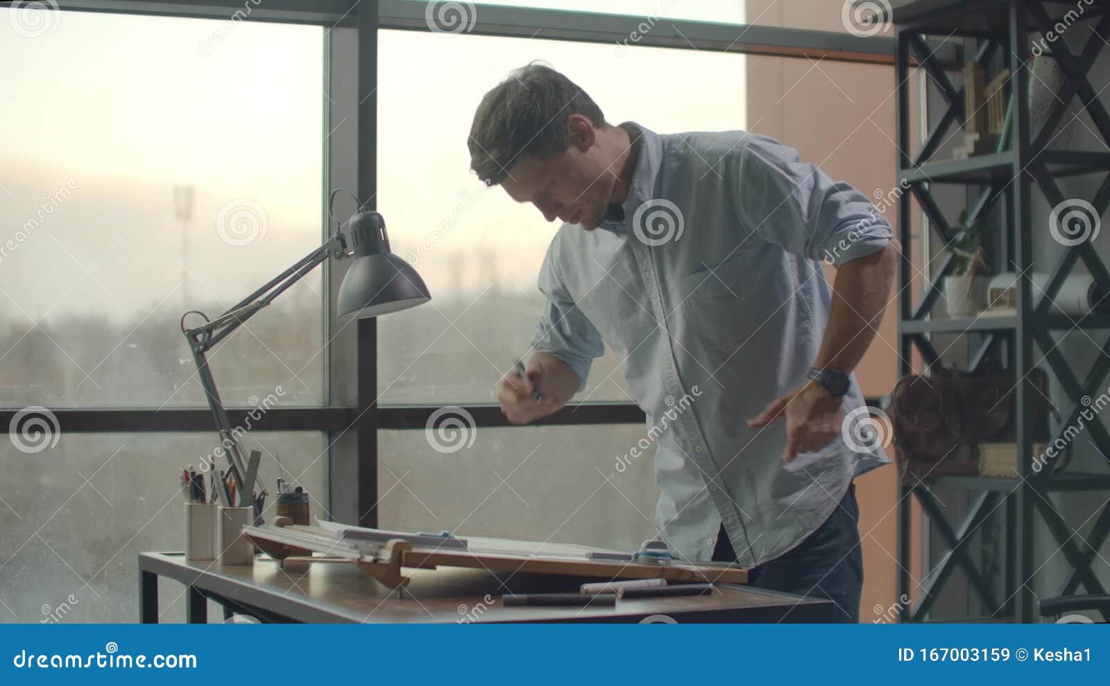 Architect Man Sits at Drafting Table in Modern Industrial Office during ...