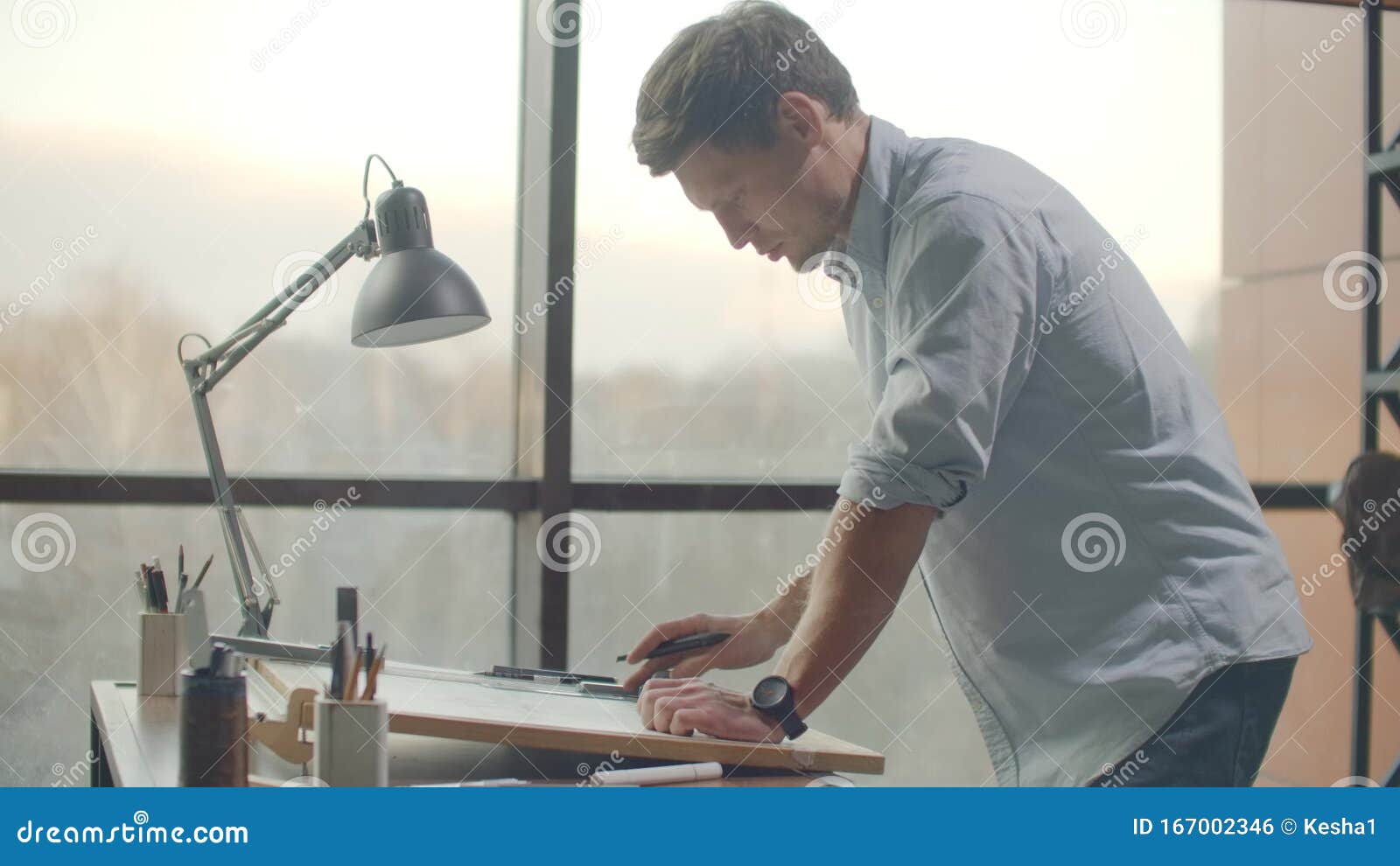 Architect Man Sits at Drafting Table in Modern Industrial Office during ...