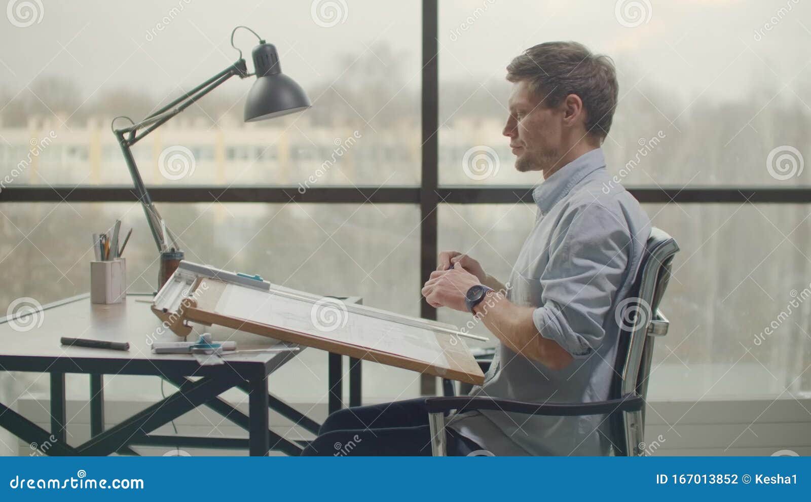Architect Man Sits at Drafting Table in Modern Industrial Office during ...
