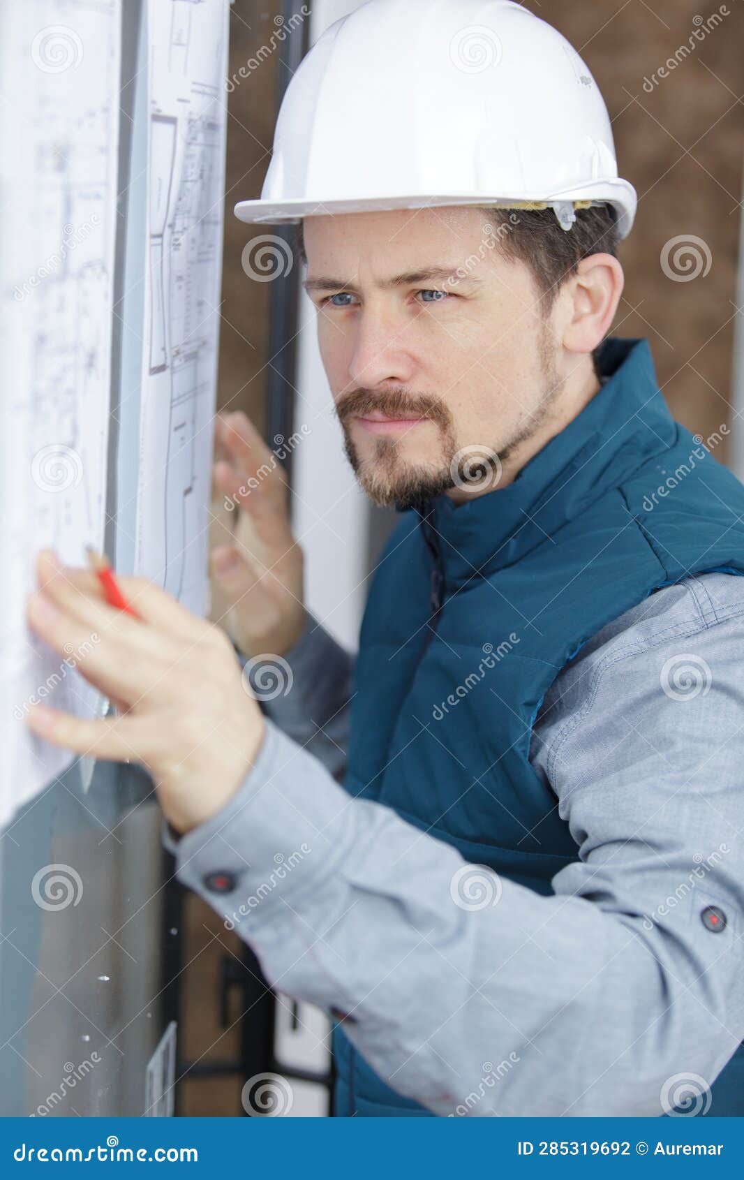 Architect Studying Plans on Wall Stock Photo - Image of hardhat, plans ...