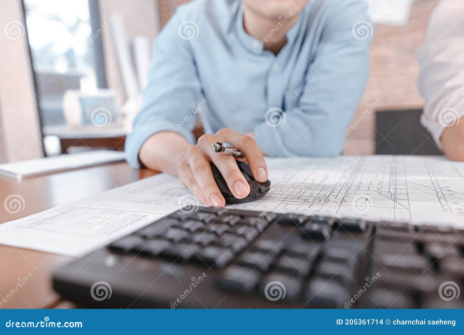 Architect Use Computer Mouse and Reading a Building and Drawing Outlay ...