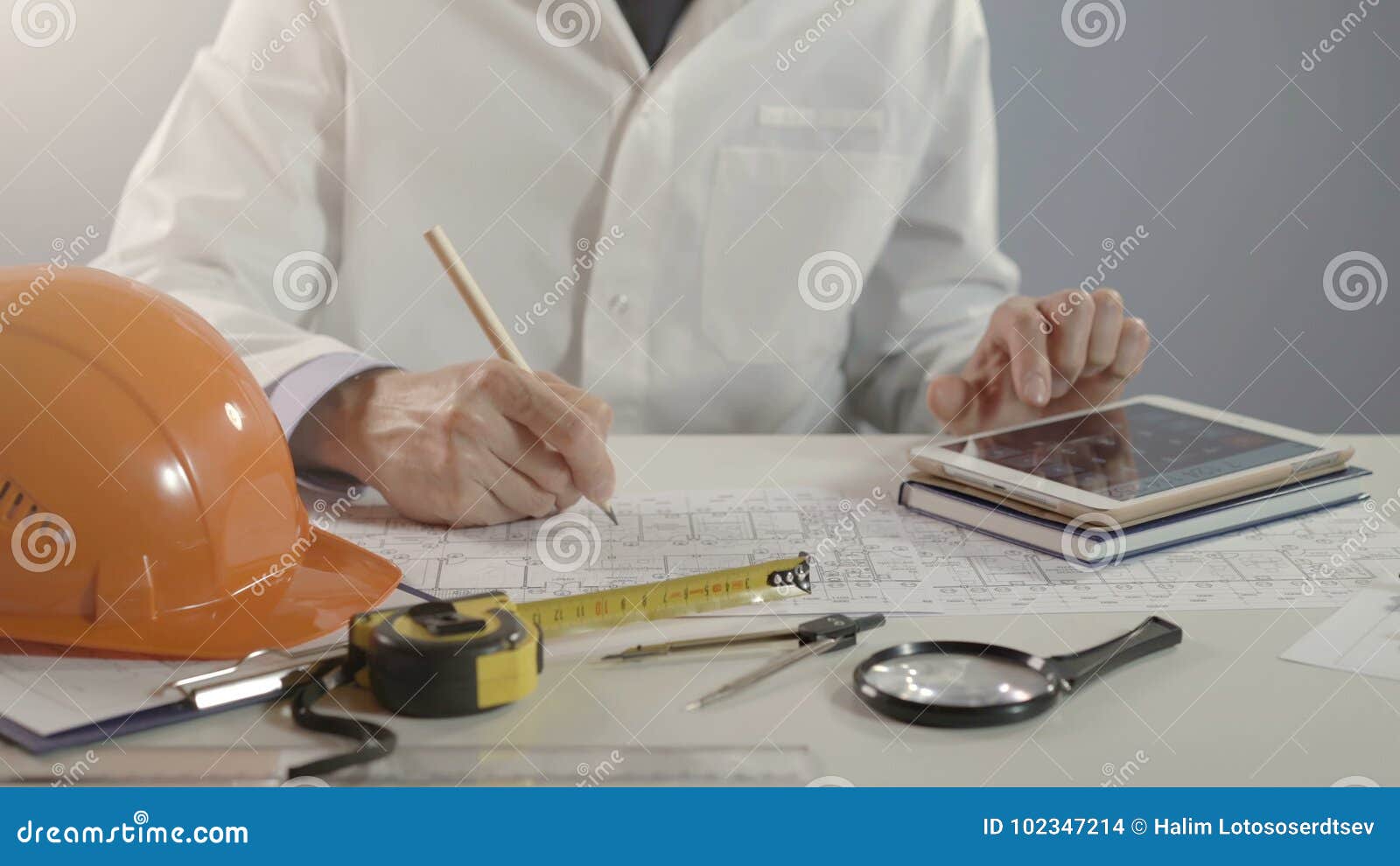 Architect or Engineer Working on Blueprint and Using Tablet Computer ...
