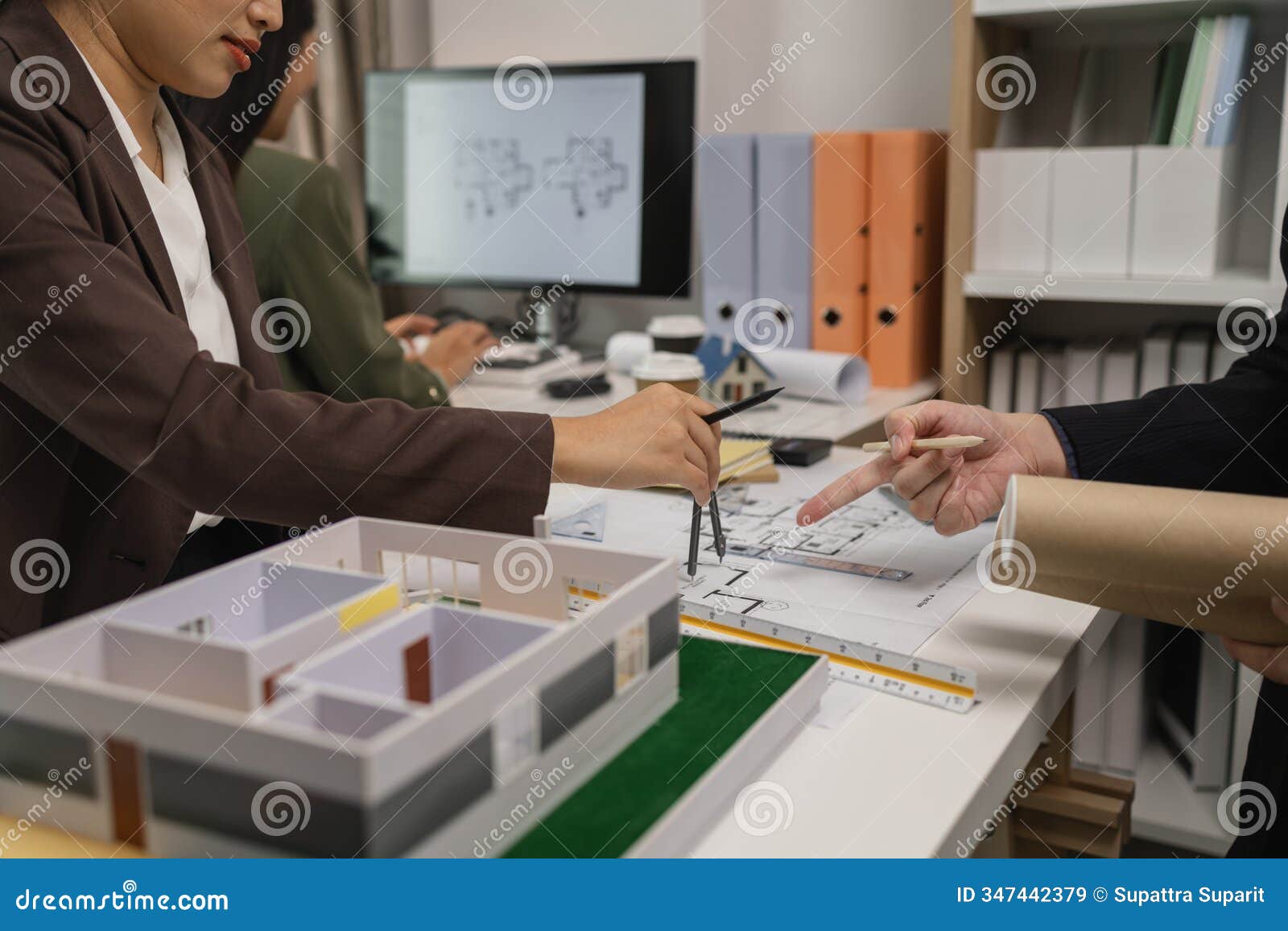 An Architect is Working in the Office with His Team, Blueprint on the ...