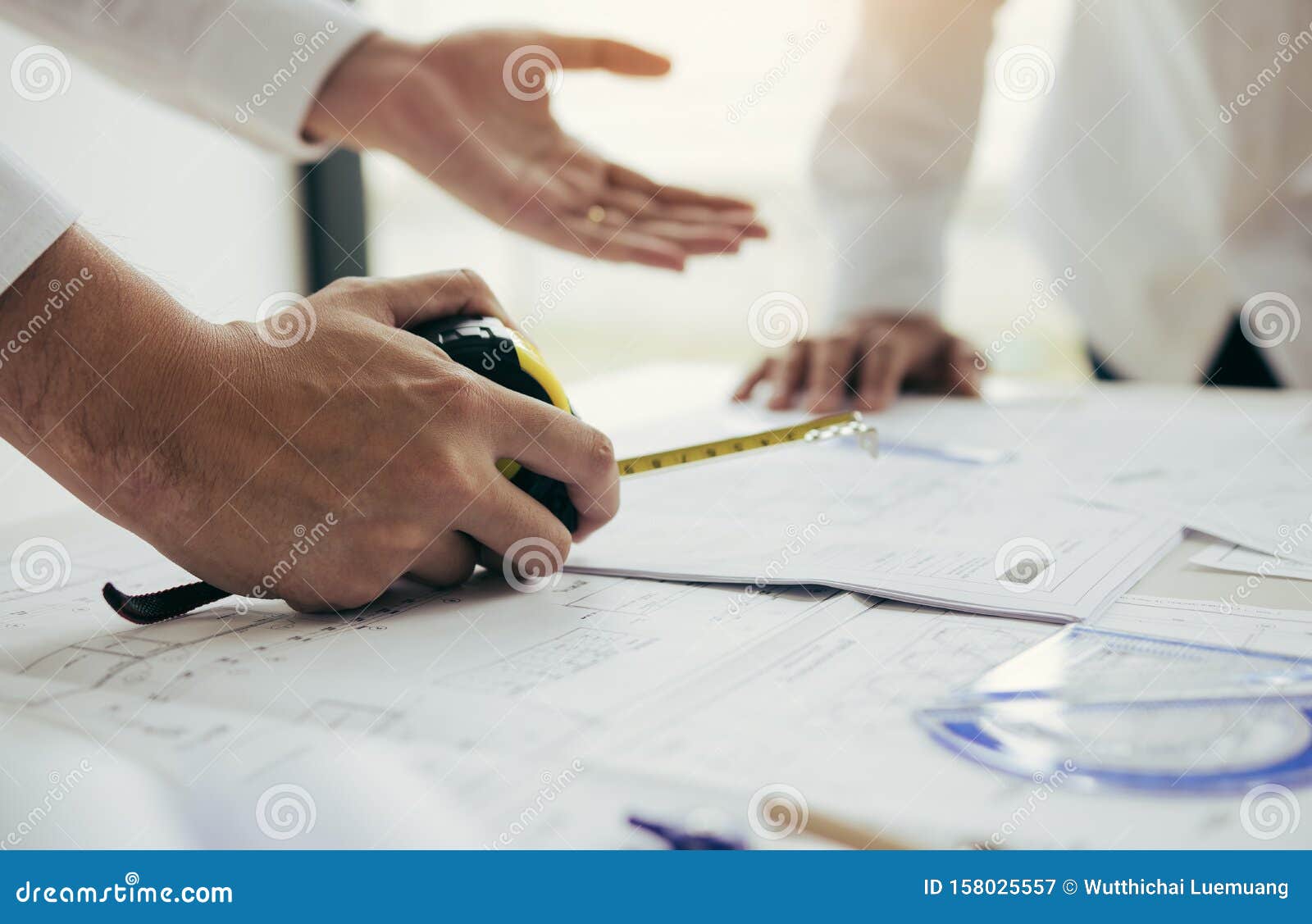 Two Engineering Working Together And Using Compass Looking Blueprint ...