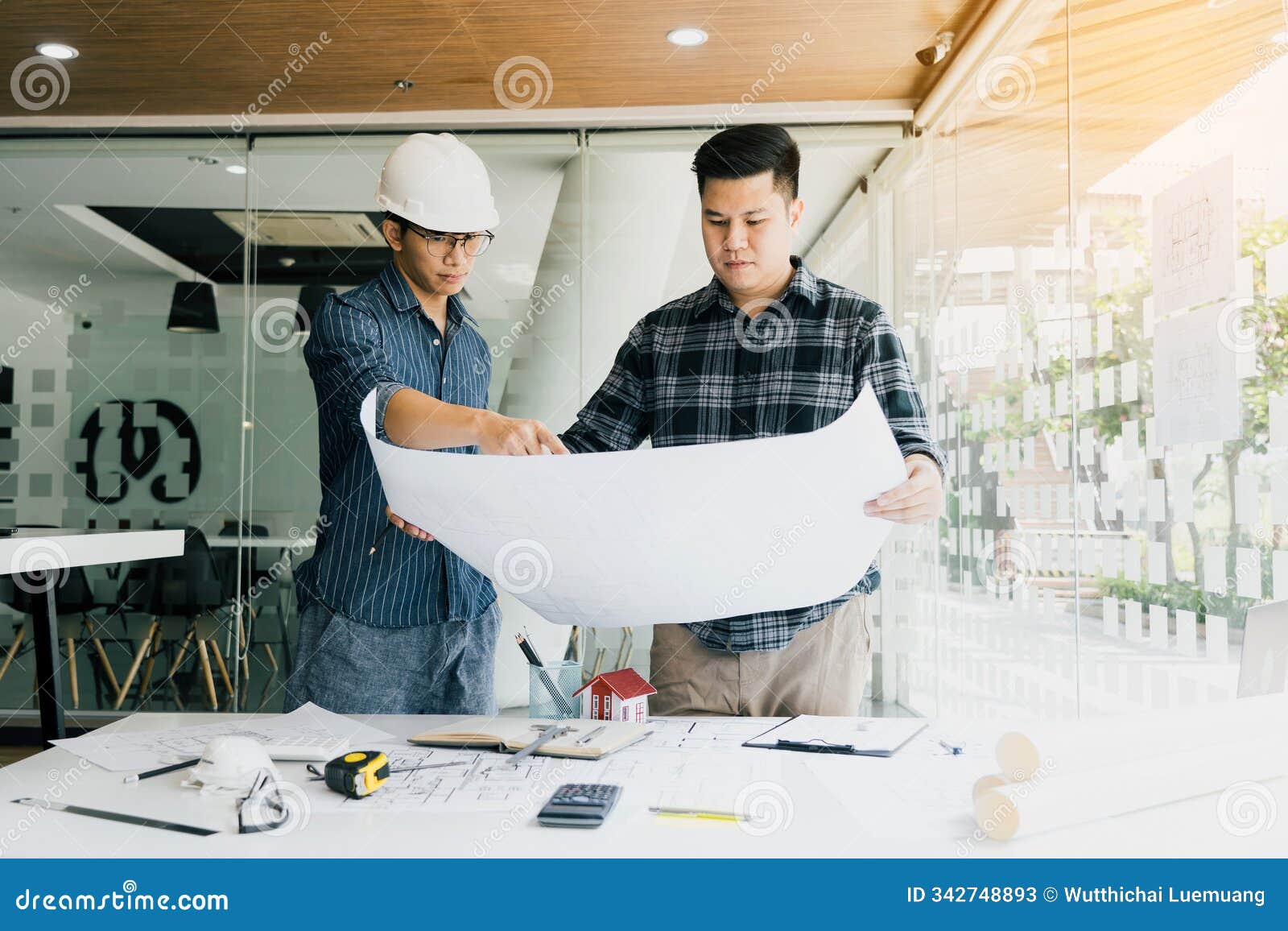 Two Engineering Working Together And Using Compass Looking Blueprint ...