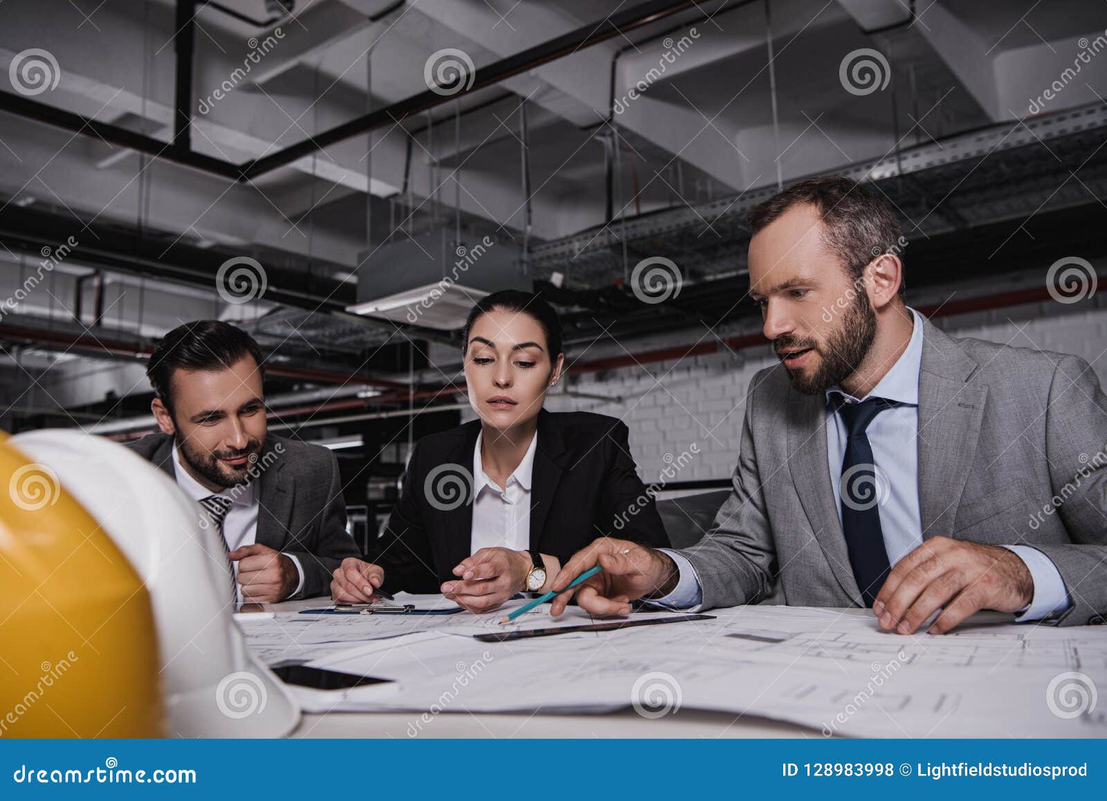 Architects and Engineers in Suits Working at Table with Blueprints ...