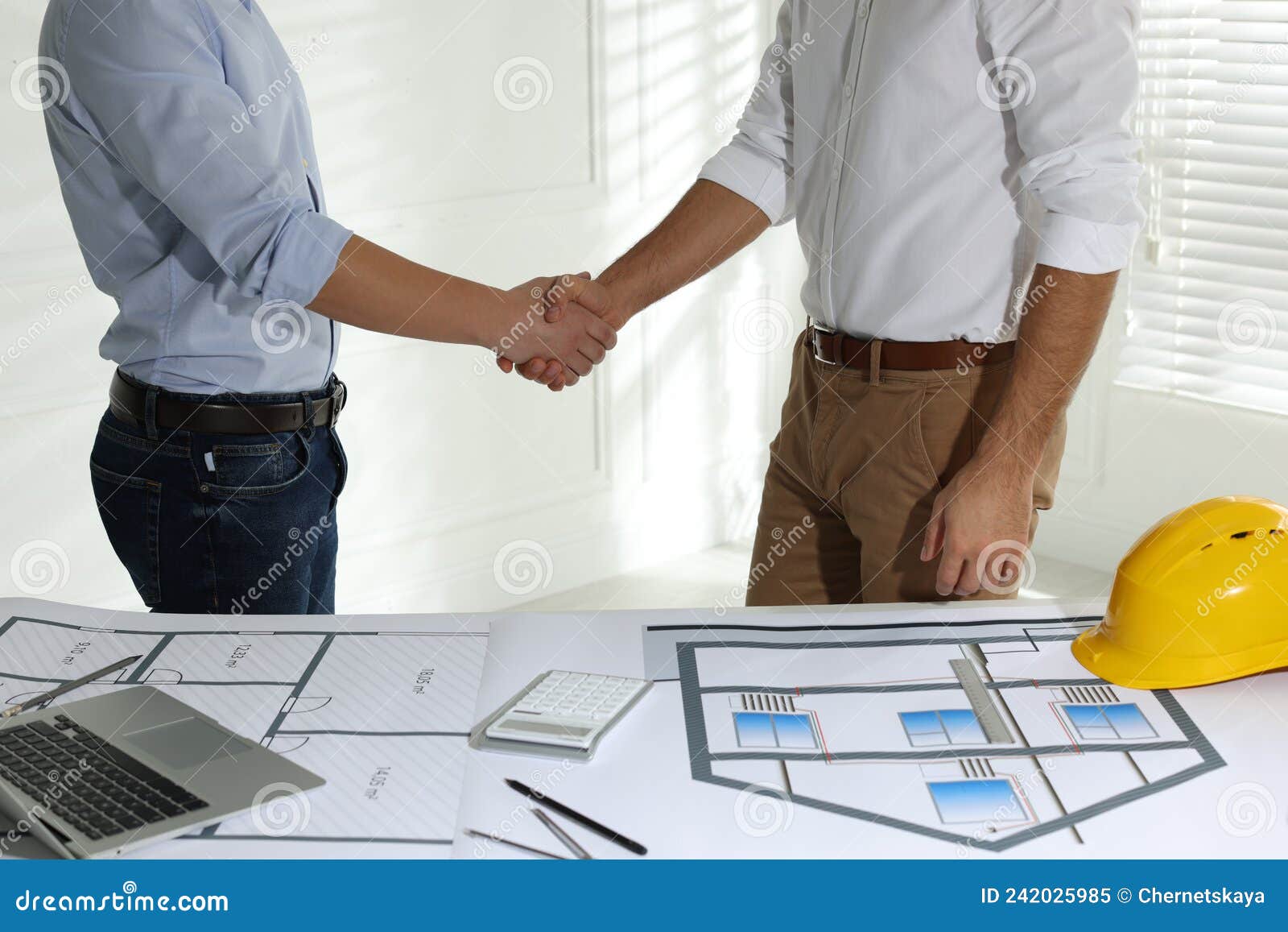 Architects Shaking Hands Near Table with Construction Projects in ...