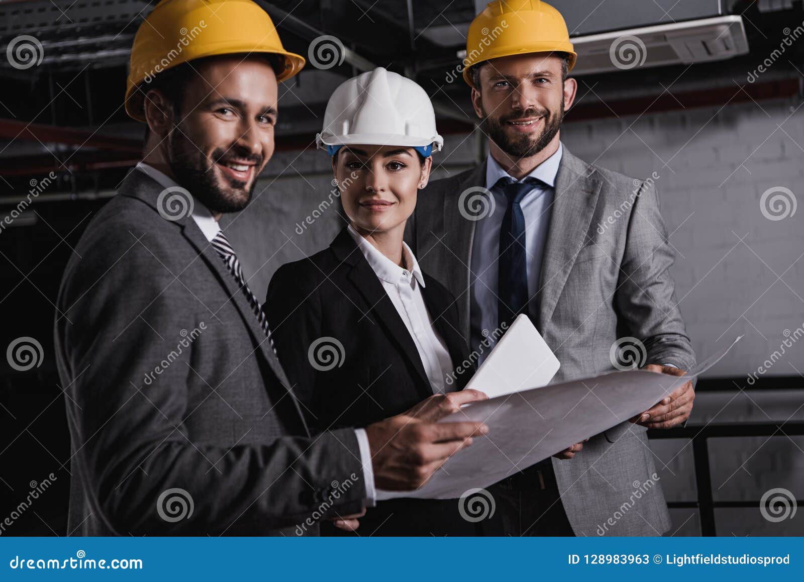 Architects in Suits and Helmets Working with Blueprint and Digital ...