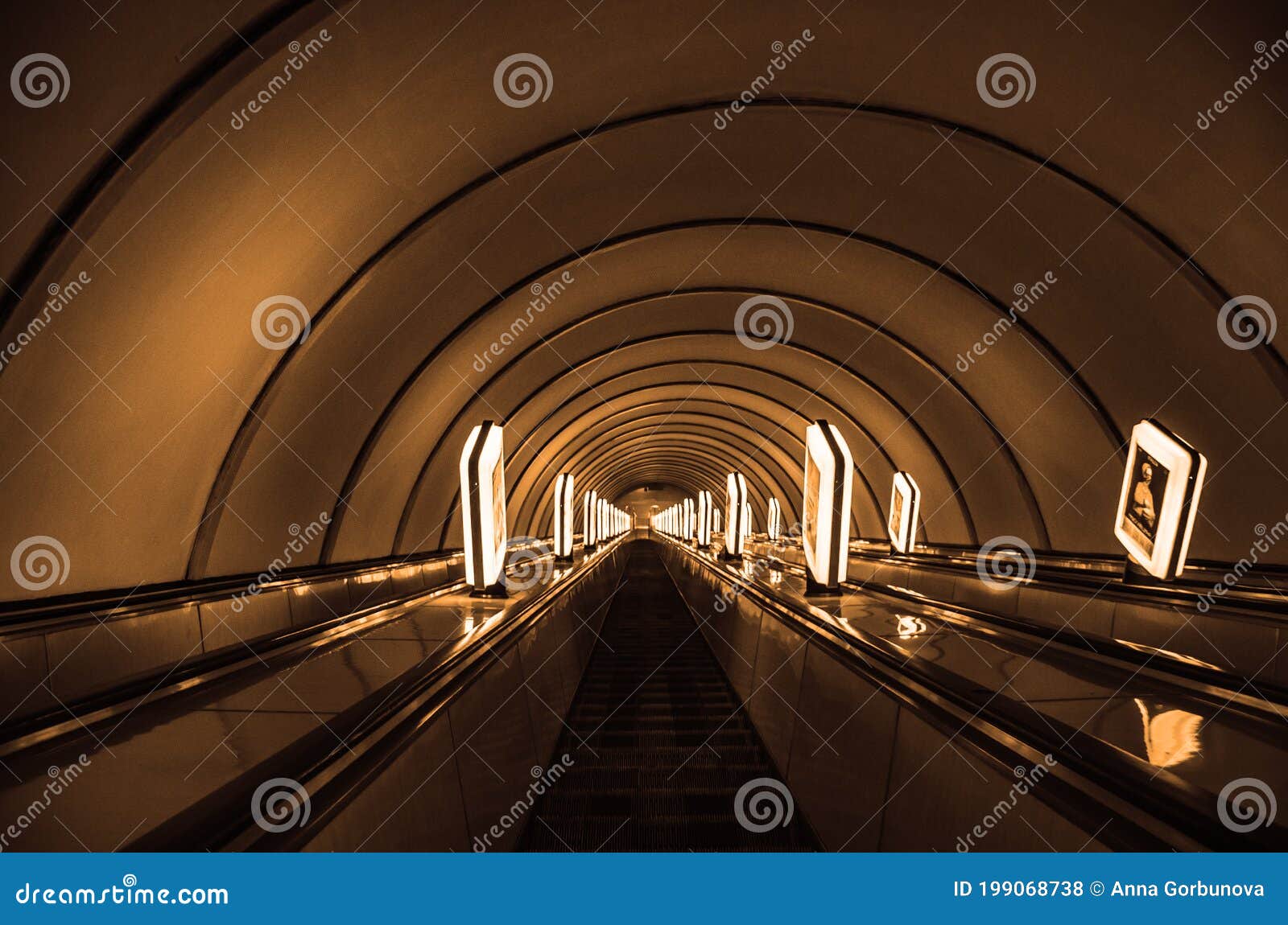 Descent On The Escalator In The Metro. Light Boxes Along The Tunnel ...