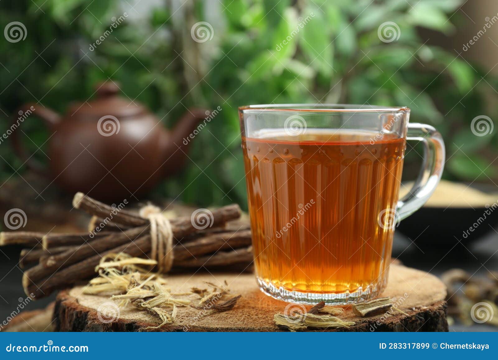 Aromatic Licorice Tea in Cup and Dried Sticks of Licorice Root on Table ...