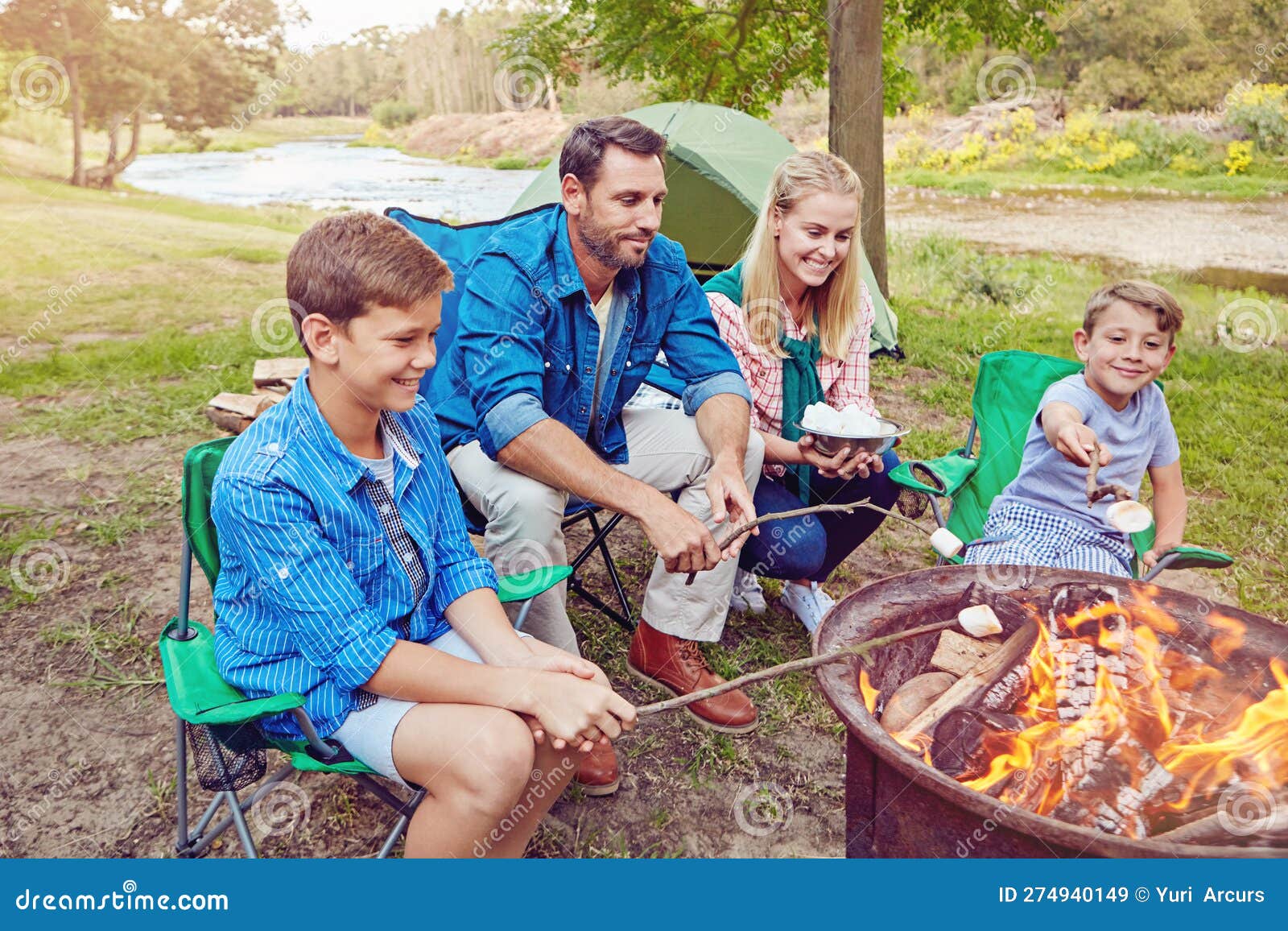 Around the Campfire. a Family of Four Camping in the Woods. Stock Image ...
