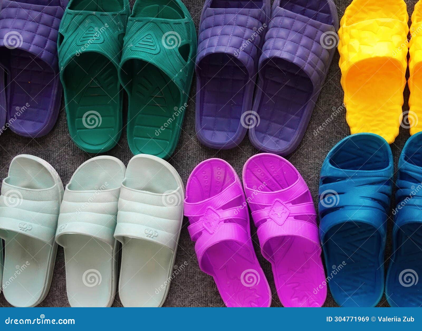 An Array of Brightly Colored Slides and Sandals is Neatly Organized in ...