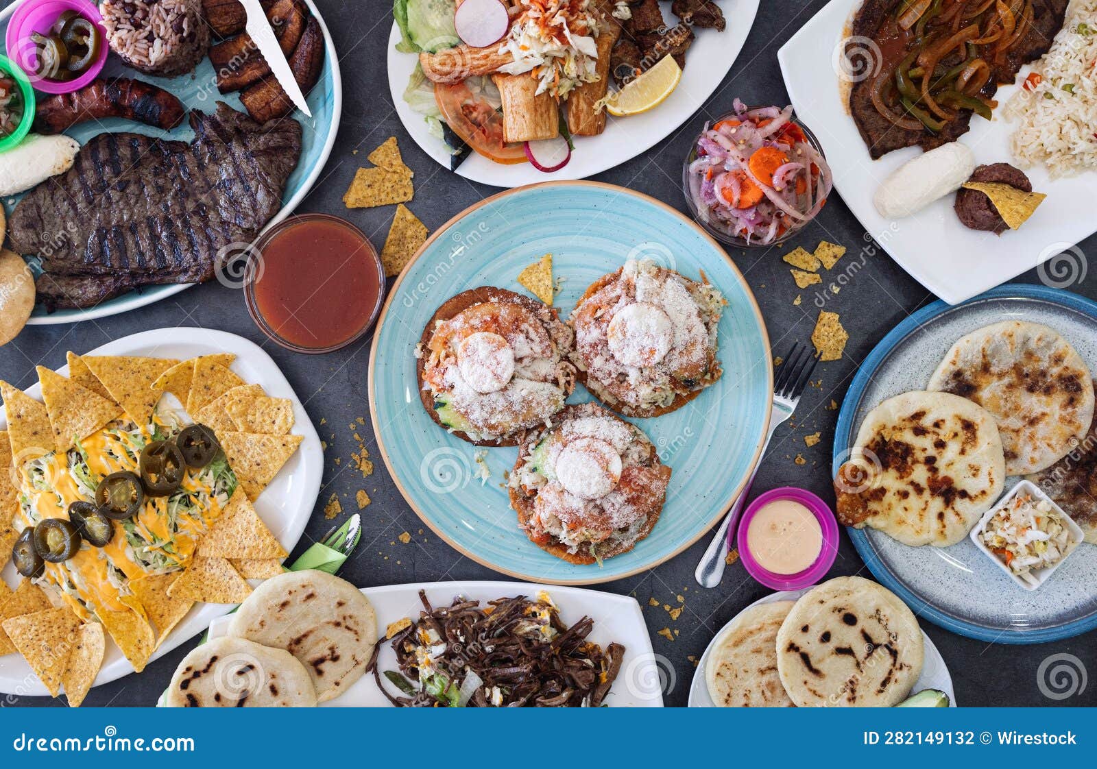 Several Different Plates of Food Laid Out on a Table with Forks and ...