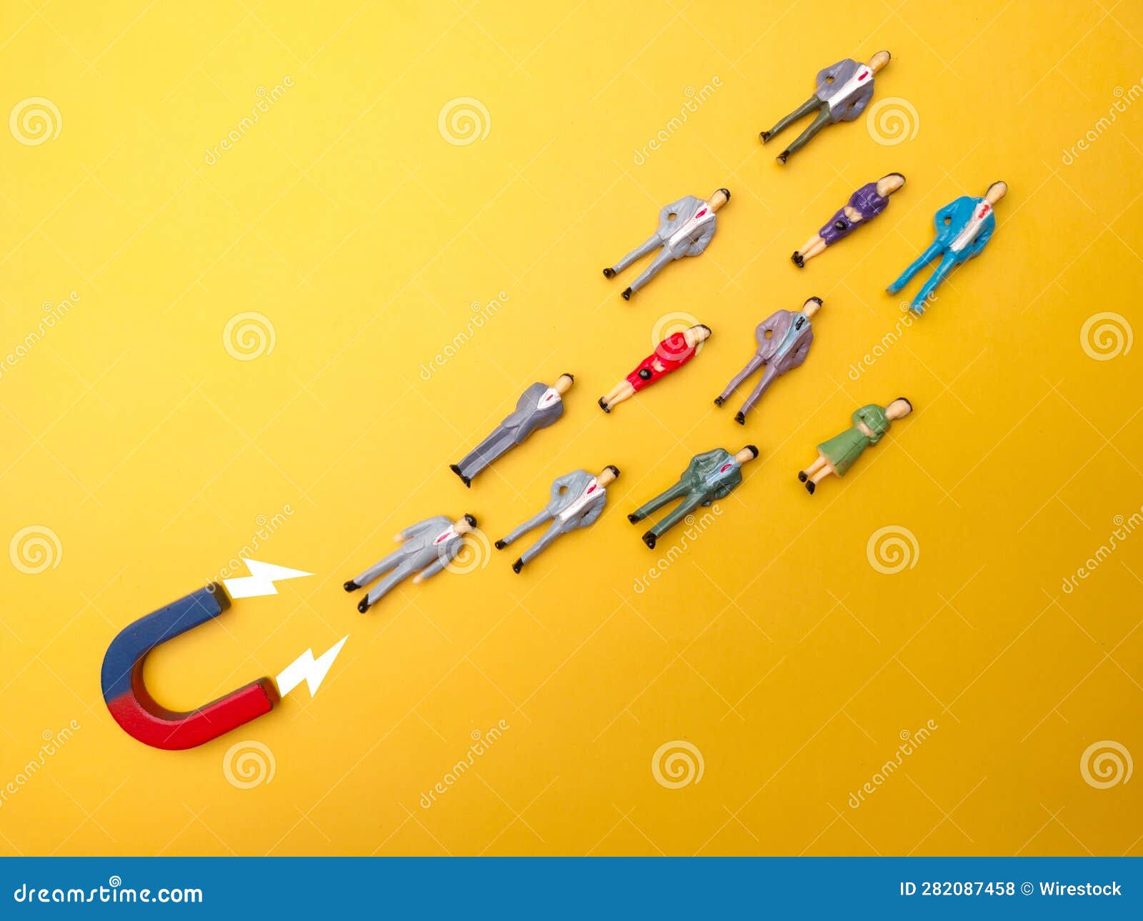 Array of Figurines Arranged in a Pattern with a Magnet and an Arrow ...