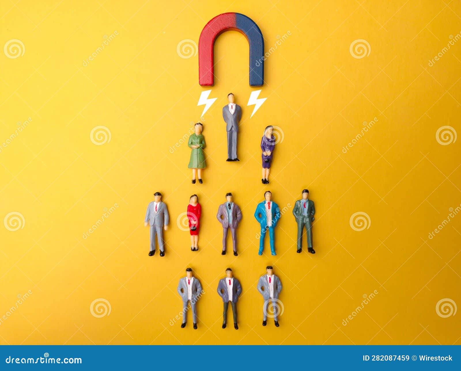 Array of Figurines Arranged in a Pattern with a Magnet and an Arrow ...