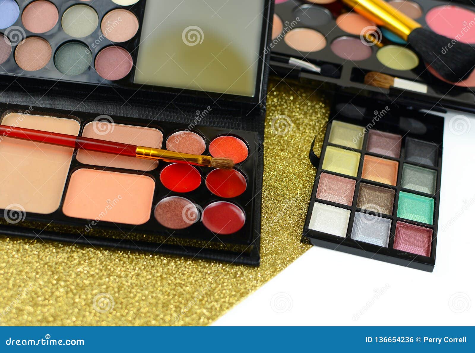 An Array of Makeup or Cosmetics Scattered Over a Gold Glitter ...