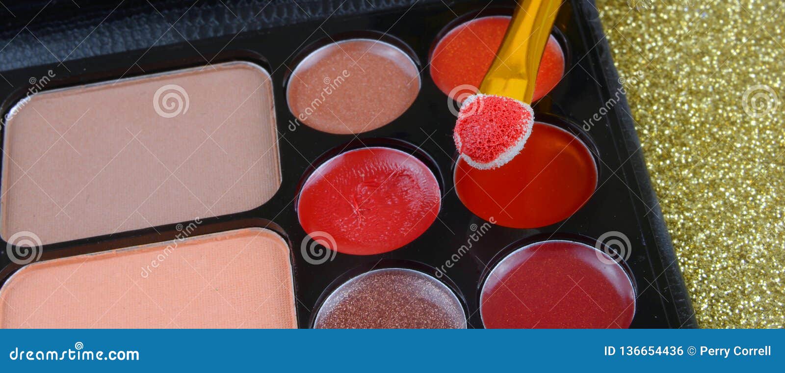 An Array Of Makeup Or Cosmetics Scattered Over A Gold Glitter ...