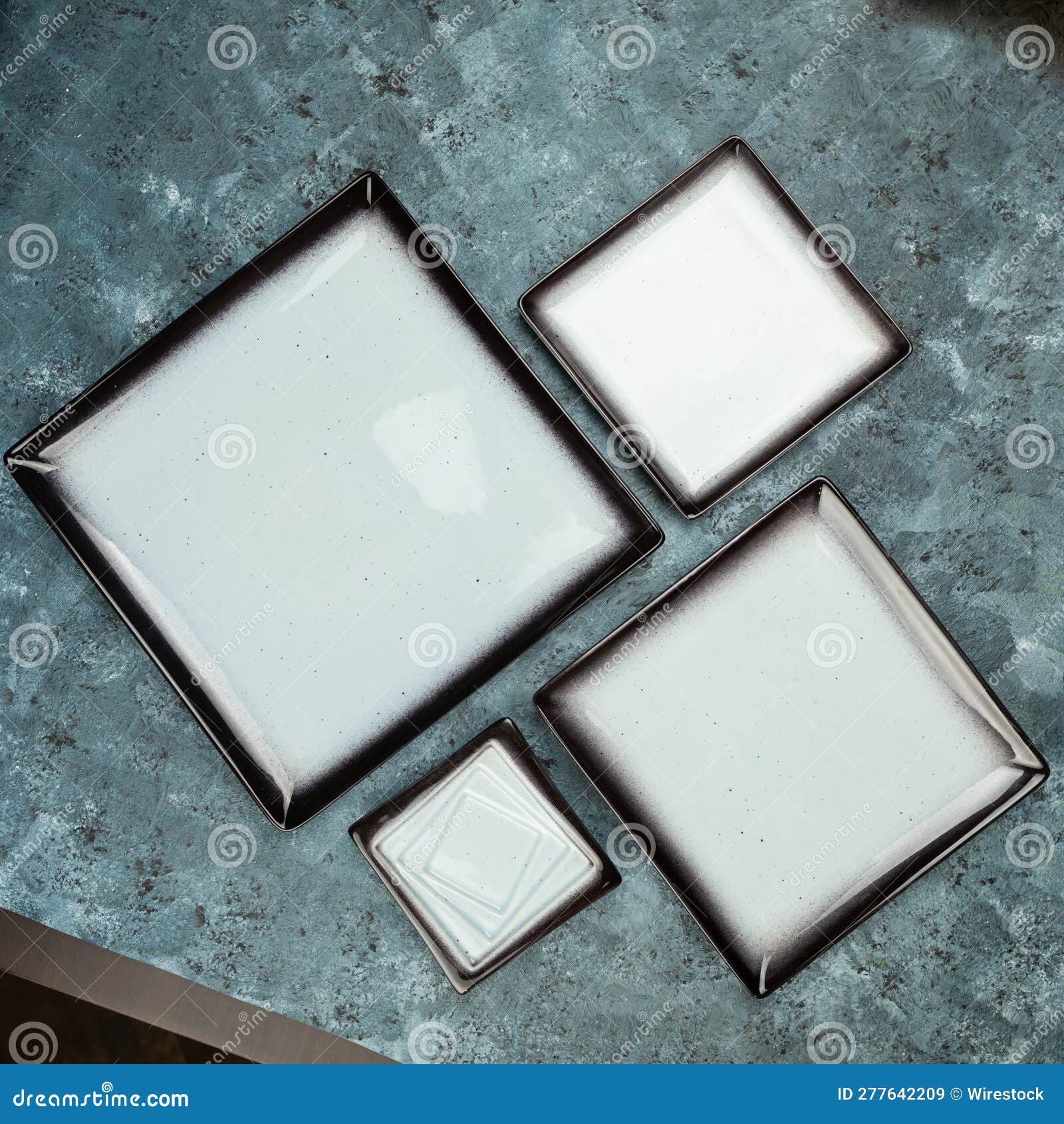 Array of Square Ceramic Plates Arranged in a Neat Pattern on a Blue ...
