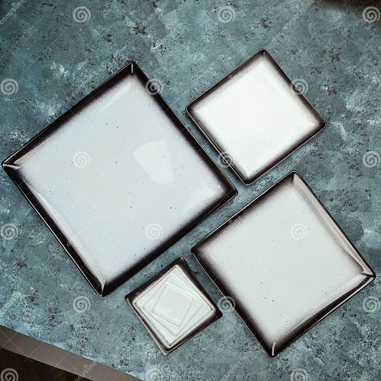 Array of Square Ceramic Plates Arranged in a Neat Pattern on a Blue ...