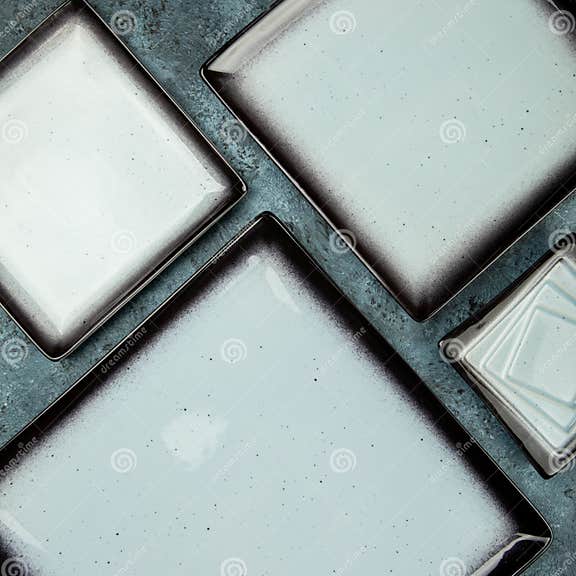 Array of Square Ceramic Plates Arranged in a Neat Pattern on a Blue ...