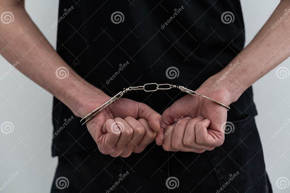 Arrested Man with Cuffed Hands Behind Prison Bars. Stock Photo - Image ...