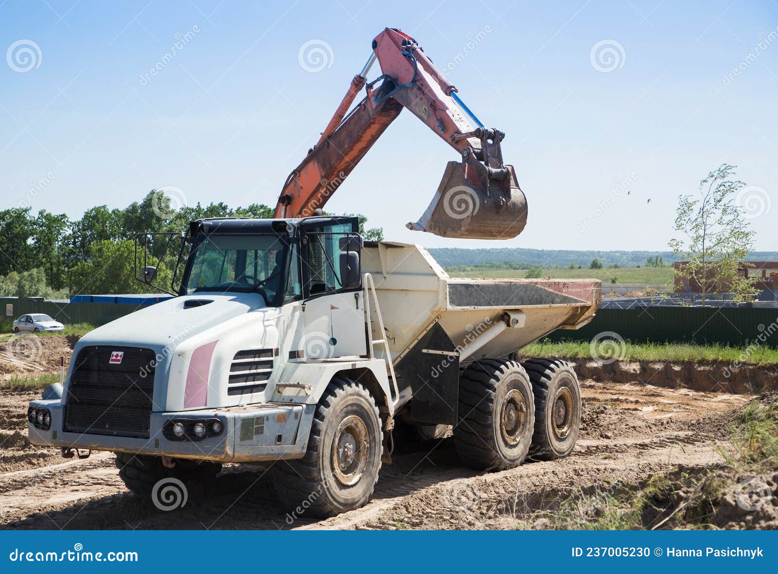 Articulated Dump Truck and an Excavator Standing Behind it at a ...