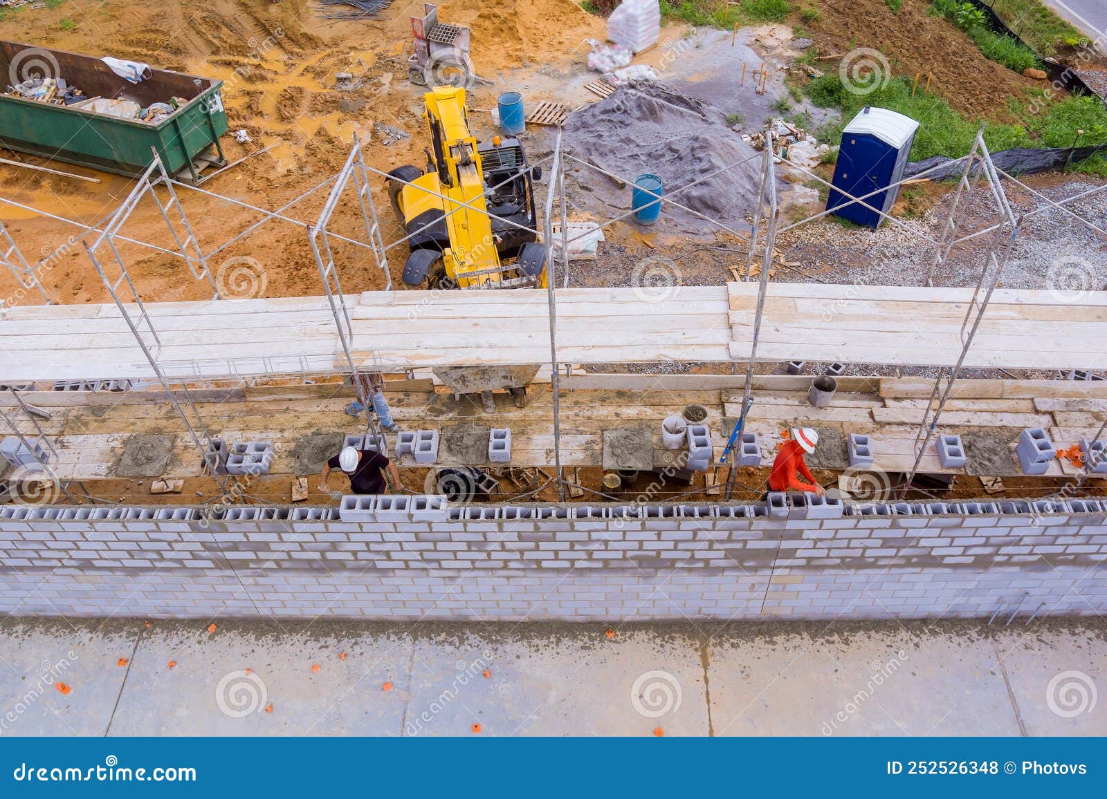 As Construction Workers Work on Scaffolding, they Lay Down Masonry ...