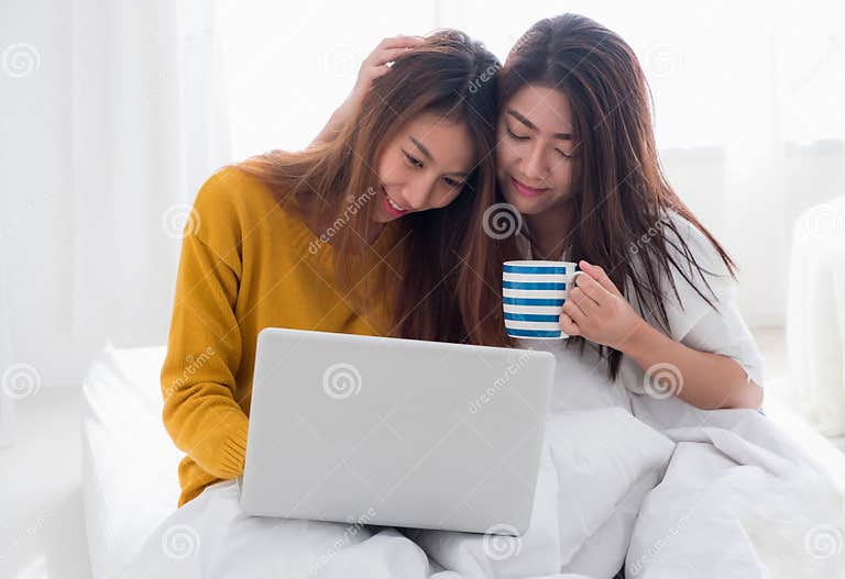 Asia Lesbian Lgbt Couple Sitting On Bed Hug And Using Laptop Com Stock