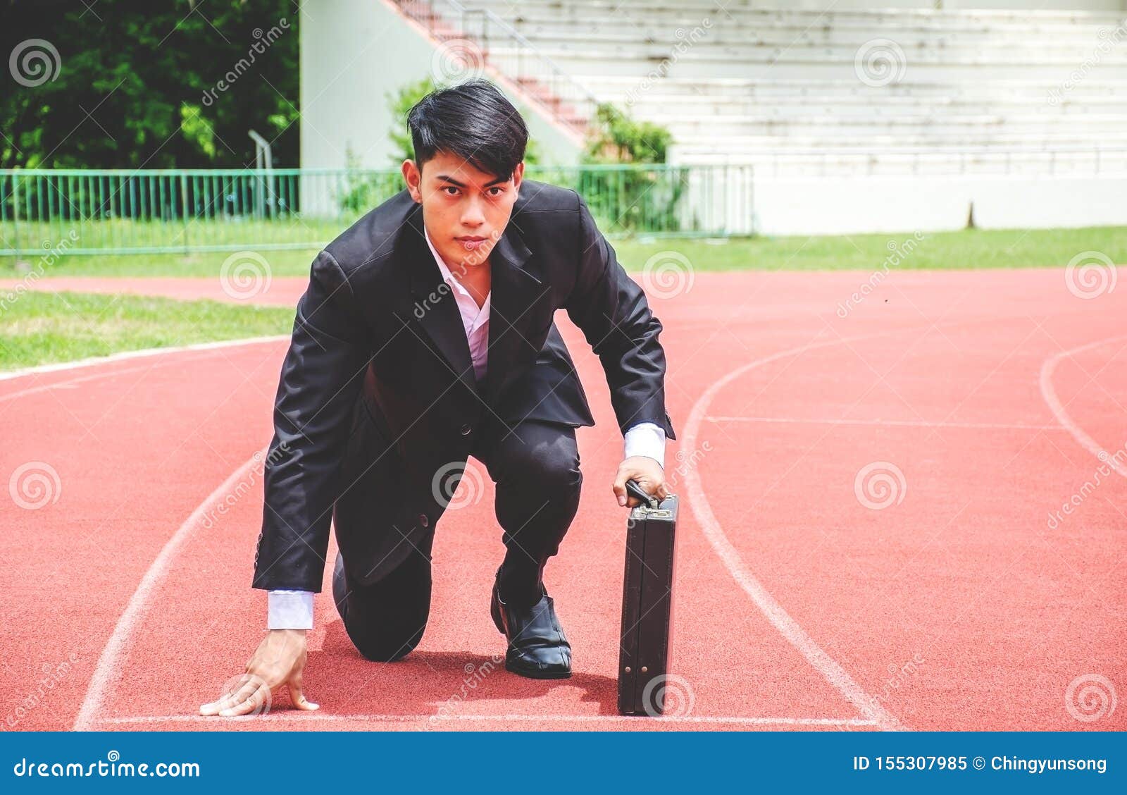 Asian Business Man Kneeling on the Starting Grid of a Running Track ...