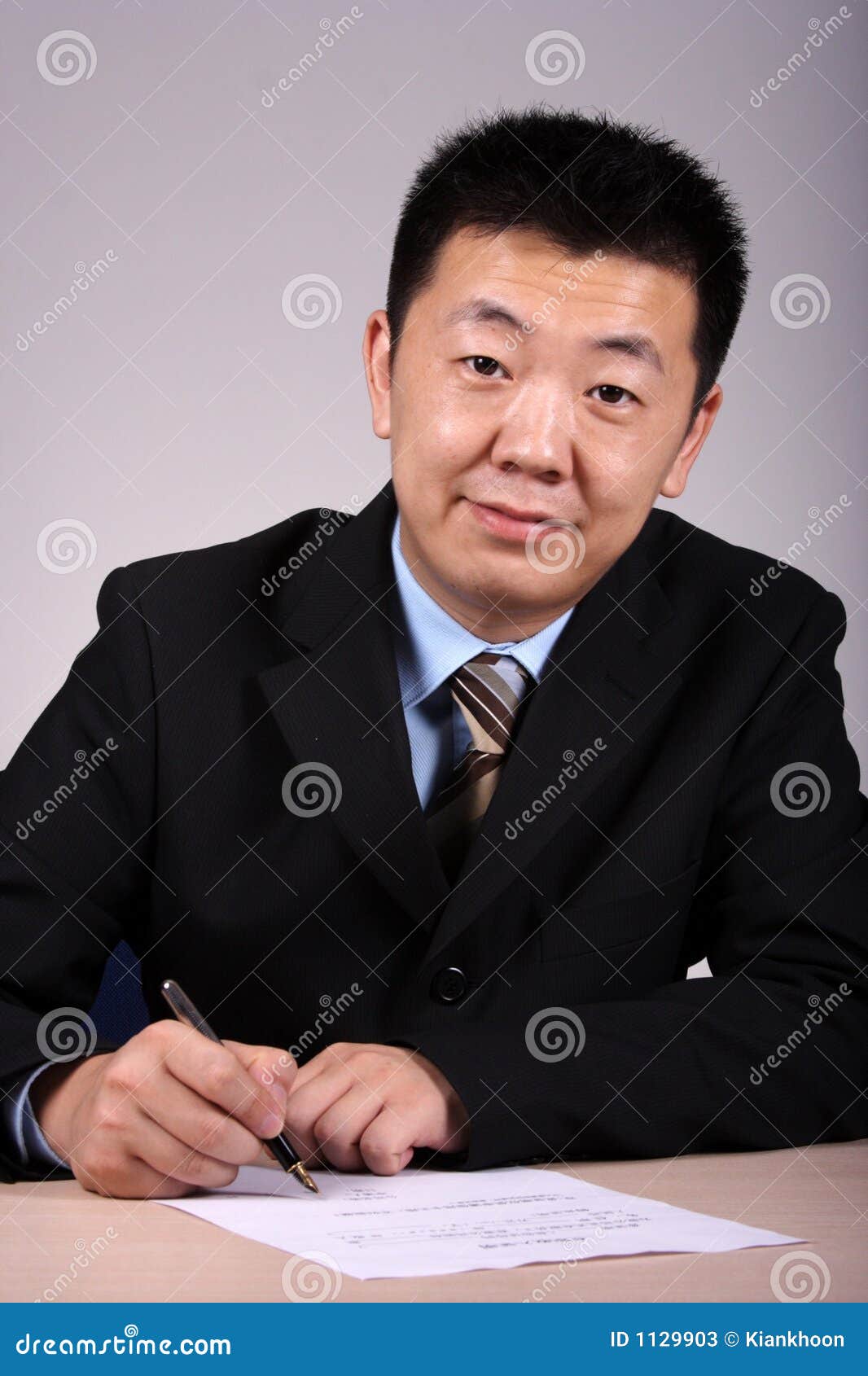 Asian Businessman Writing stock image. Image of paper - 1129903