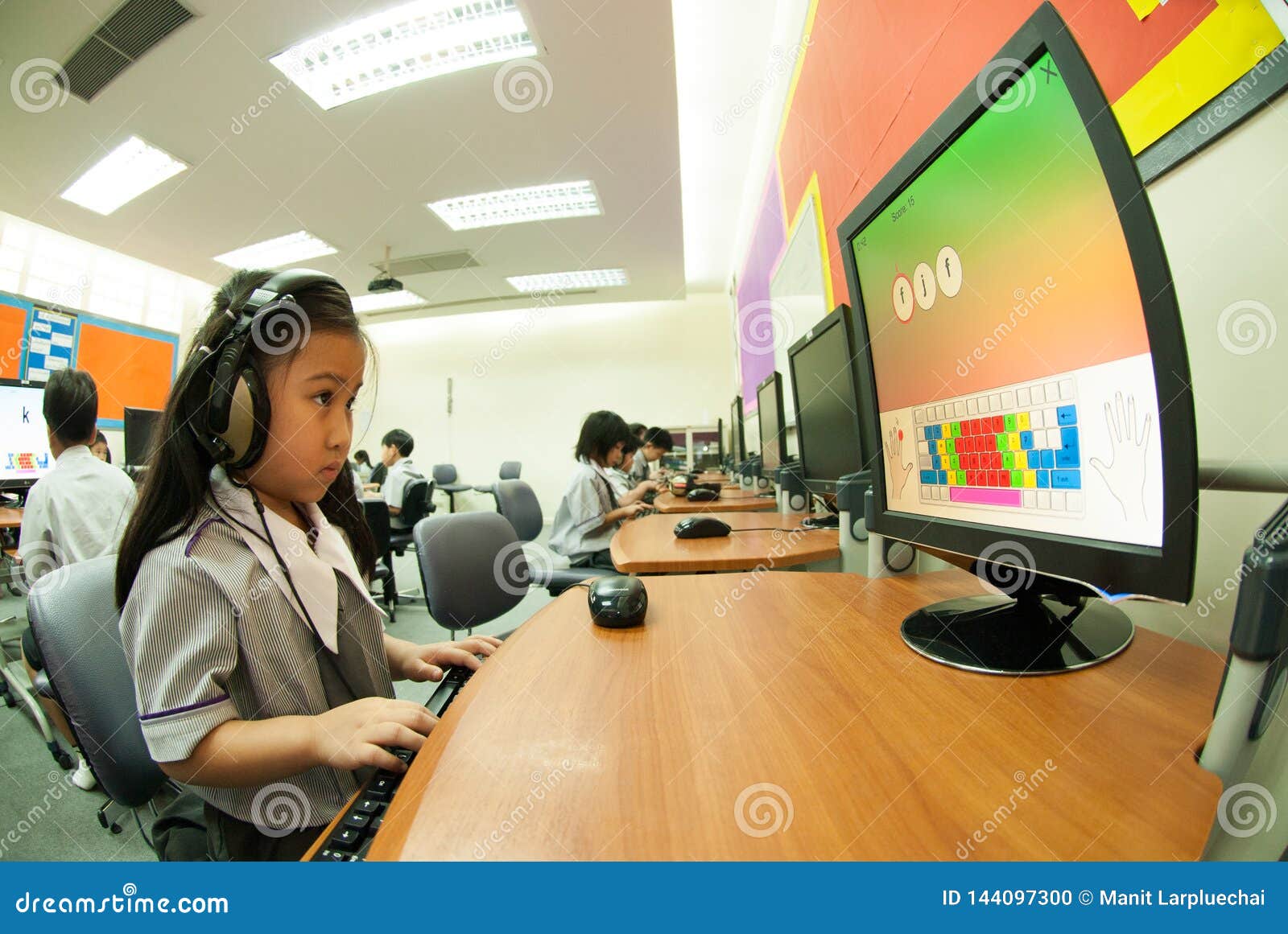 Asian Elementary Child Learning To Use Computer in Classroom. Editorial ...