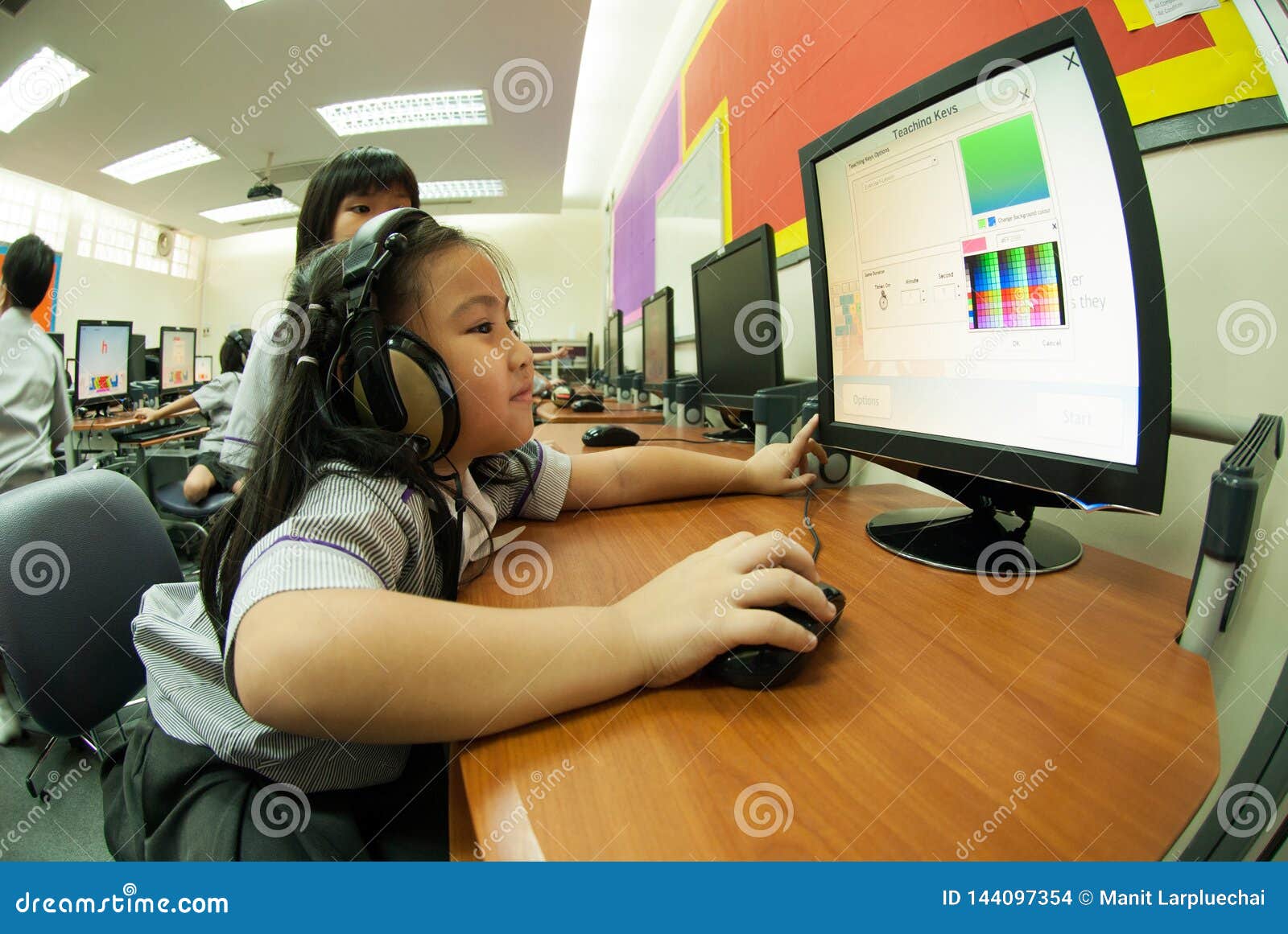 Asian Elementary Child Learning To Use Computer in Classroom. Editorial ...