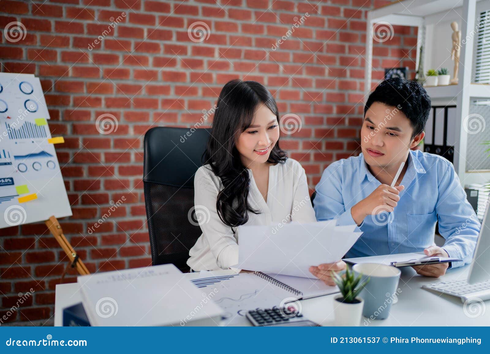 Asian Colleagues Exchanging Ideas on Their Desks. they Work Hard Every ...