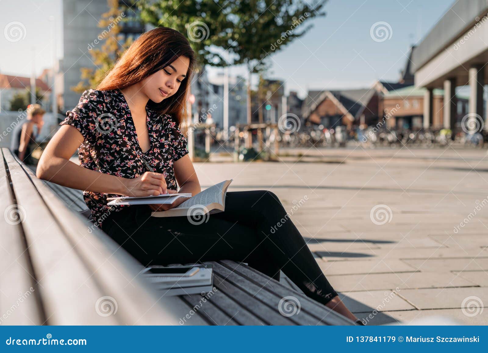 Asian College Student Sitting on a Campus Bench Studying Stock Image ...