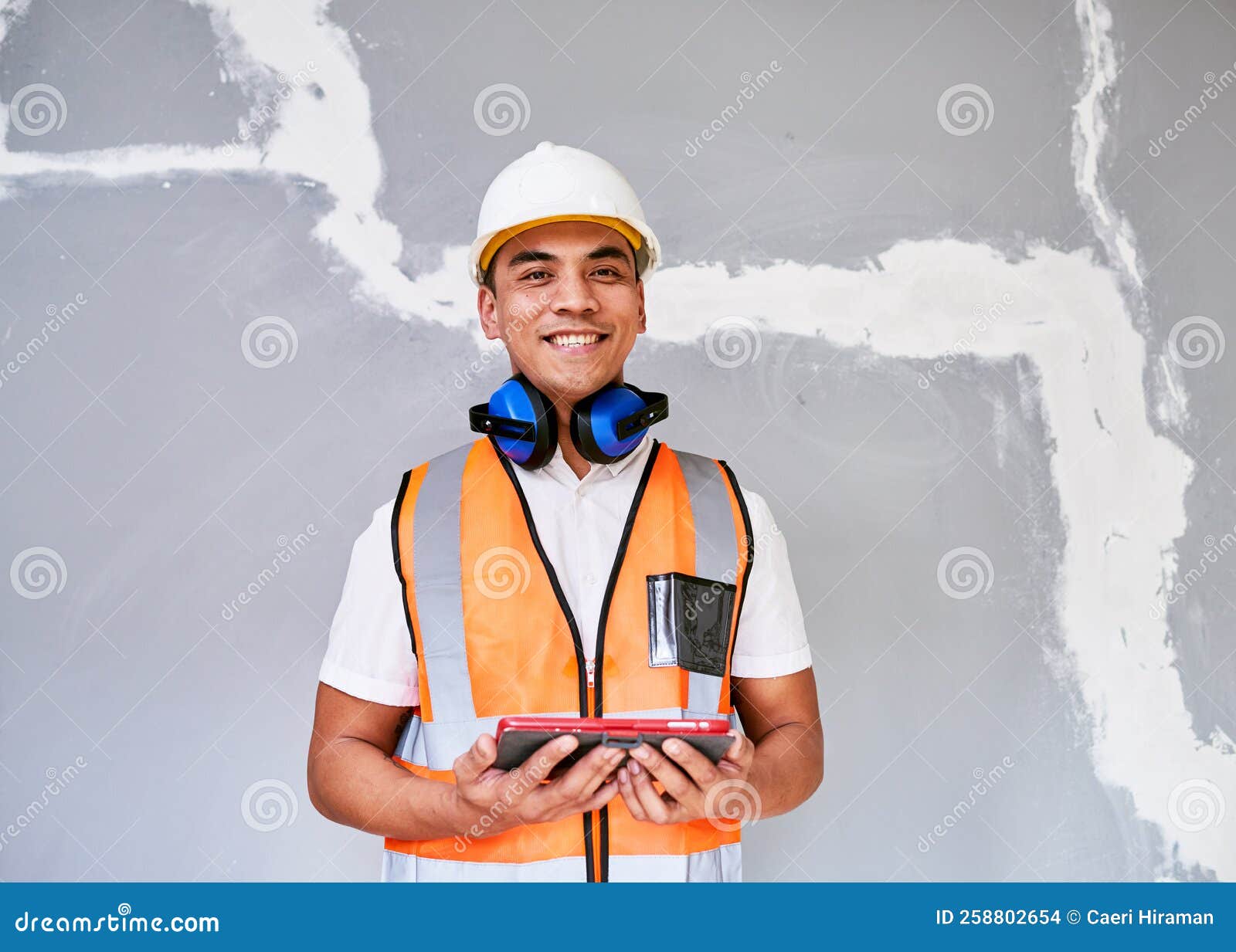 An Asian Construction Worker Smiles Looking at Camera with Digital ...