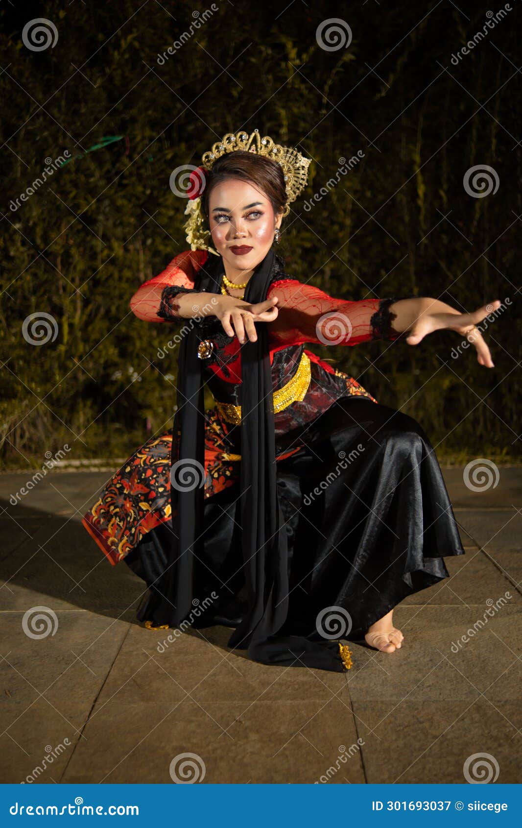 An Asian Dancer in a Red Costume Poses Very Flexibly on a Stage Stock ...