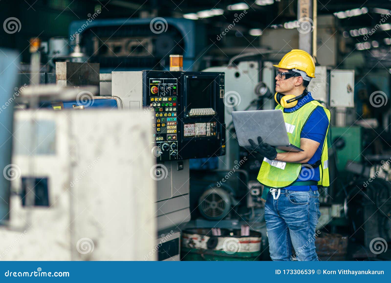 Asian Engineer Programming the Machine in Factory with Laptop Computer ...