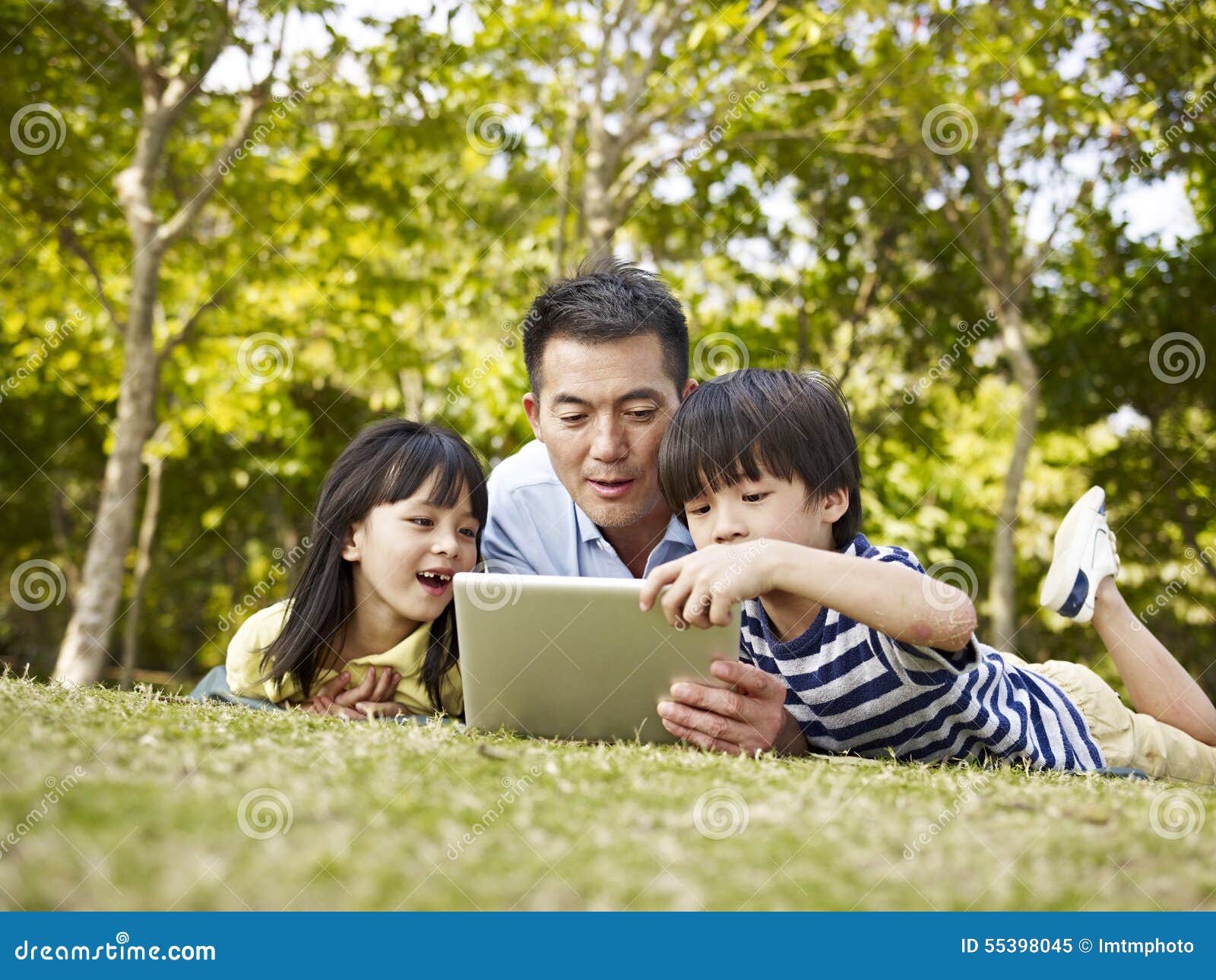 Asian Father and Children Using Tablet Computer Outdoors Stock Image ...