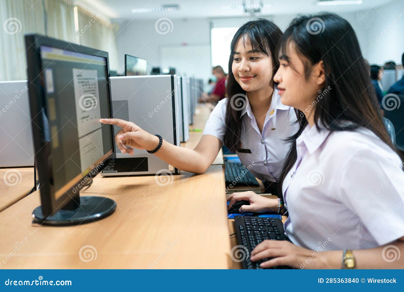 Asian Female College Students in a Classroom, Looking at a Computer ...