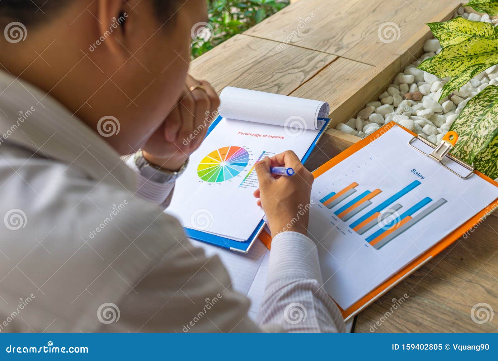 Asian Financial Executive Analyzing Data on Statistics Documents Stock ...
