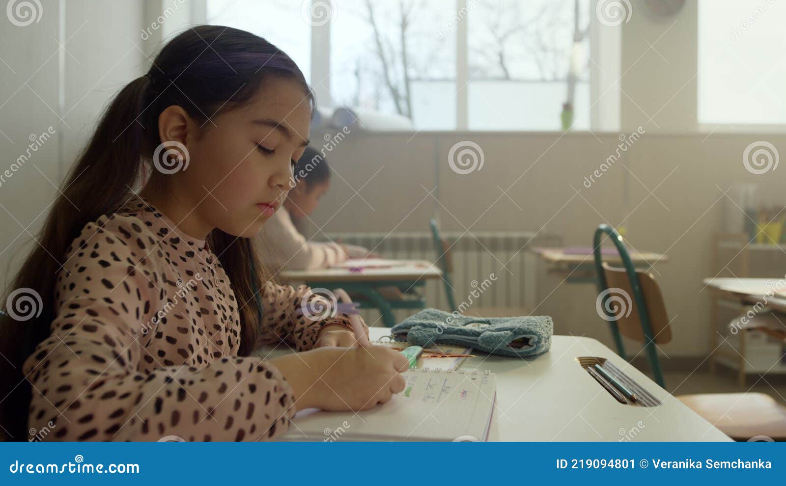 Asian Girl Learning in Classroom. Student Writing in Notebook during ...