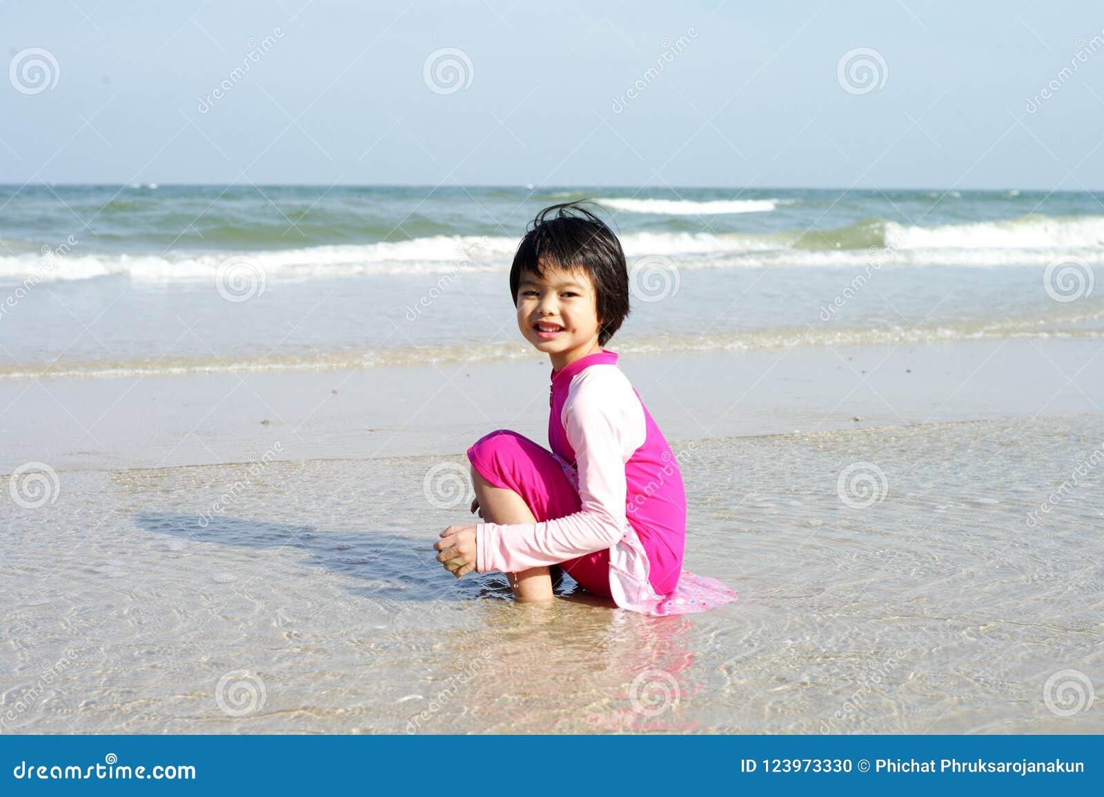 Asian Girl Plays On The Beach And Enjoys Swimming In The Sea In Stock