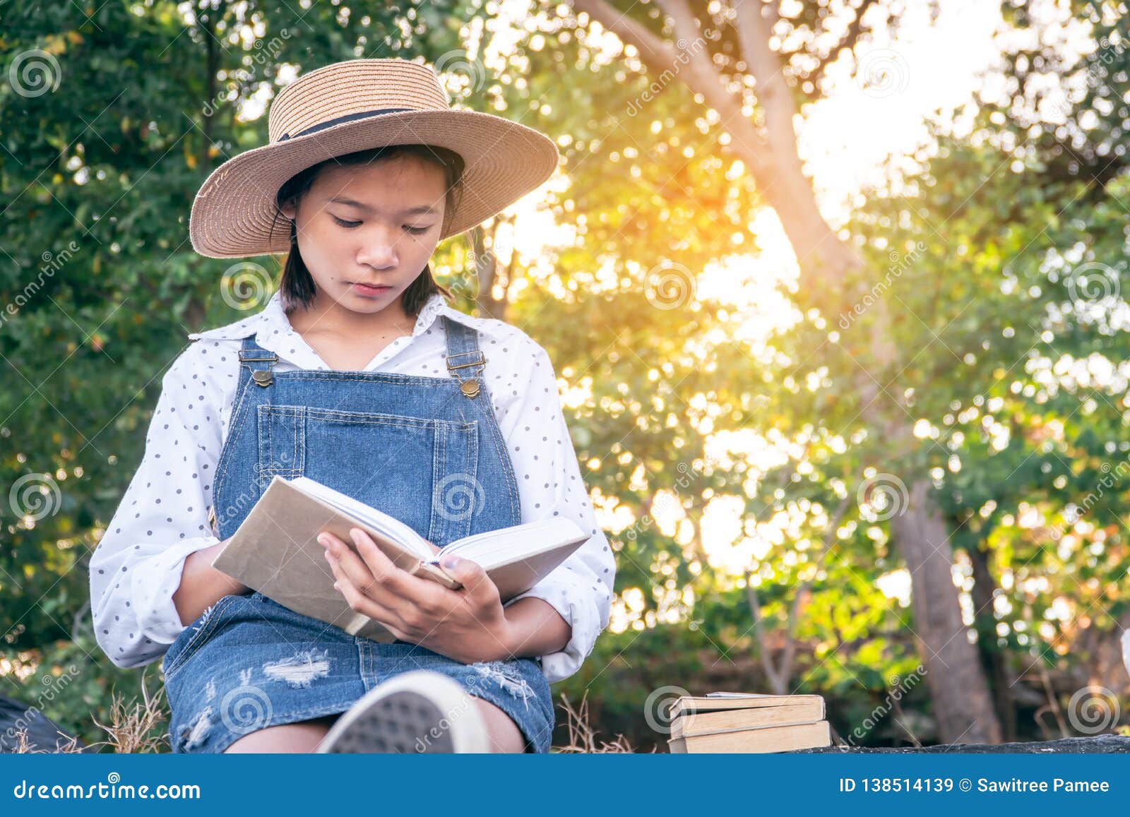 Asian girl reading a book stock image. Image of park - 138514139