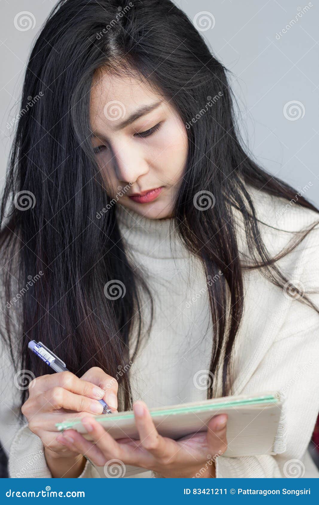 Asian girl taking notes. stock image. Image of holding - 83421211