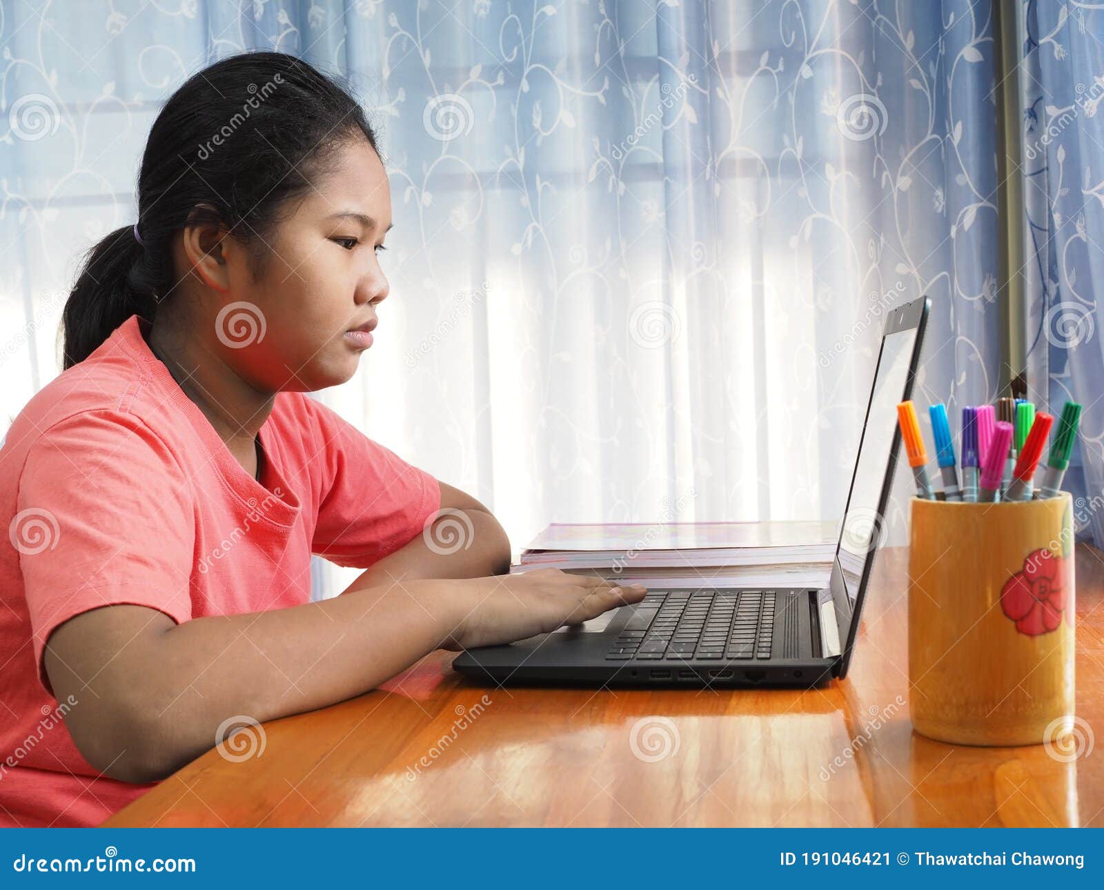 An Asian Girl is Watching a Computer Screen To Learn Online on a ...