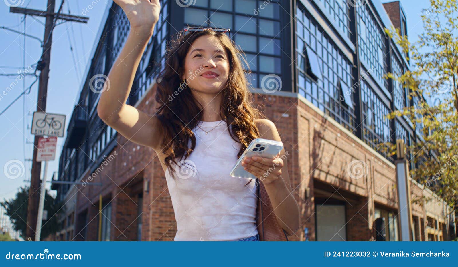 Asian Girl Waving Hand To Someone On Street Closeup Woman Meet Friends