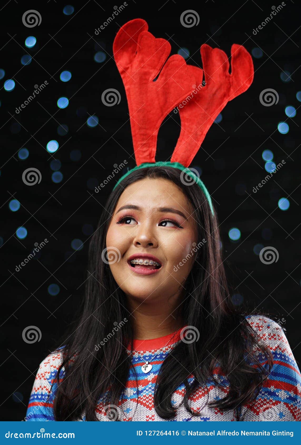 Asian Girl Wearing Christmas Sweater And Reindeer Horns Headband Stock